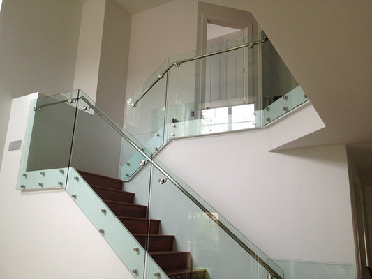 Glass railing with stainless steel standoff / patch fitting for staircase