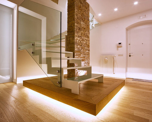 Straight wooden staircase with tempered clear glass railing indoor