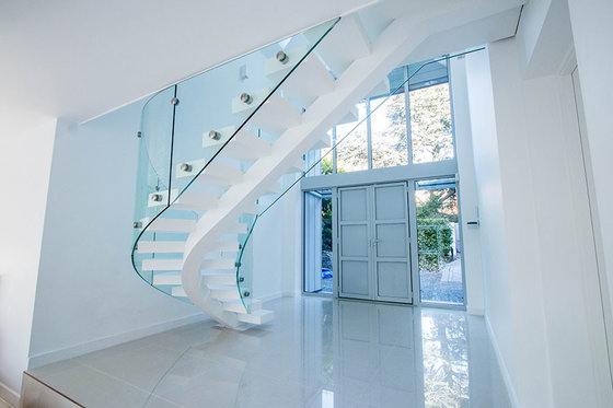 Interior white color curved staircase with glass railing design