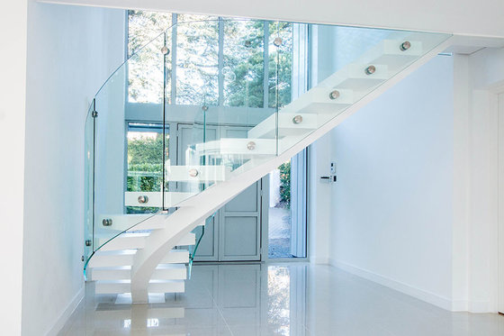 Interior white color curved staircase with glass railing design