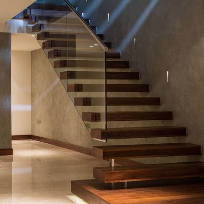 Interior floating staircase with wooden steps glass railing design