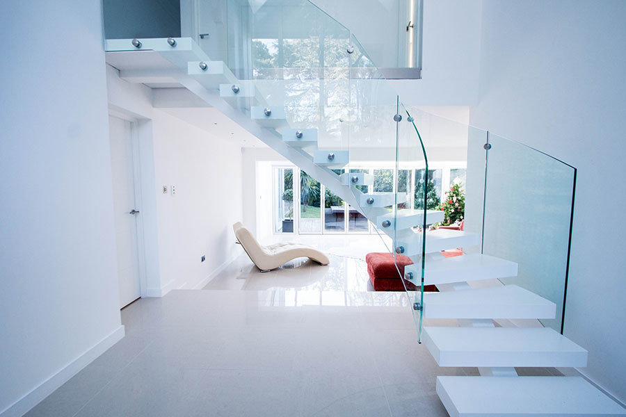 Interior white color curved staircase with glass railing design