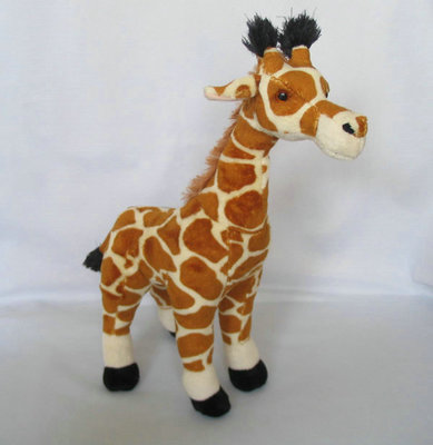 Beaux jouets de peluche de girafe de Brown reposant et tenant la pose