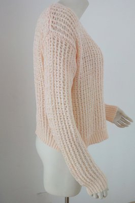 La cinta rosa clara de la malla de los suéteres del jersey de las señoras cuenta un cuento el puente cosechado