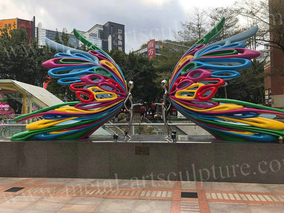 都市陸標として翼の金属の芸術の彫刻によって塗られる色の人体
