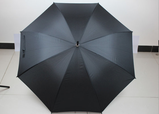 Parapluie se pliant droit ouvert de golf d'automobile, parapluie noir du golf des hommes protégeant du vent