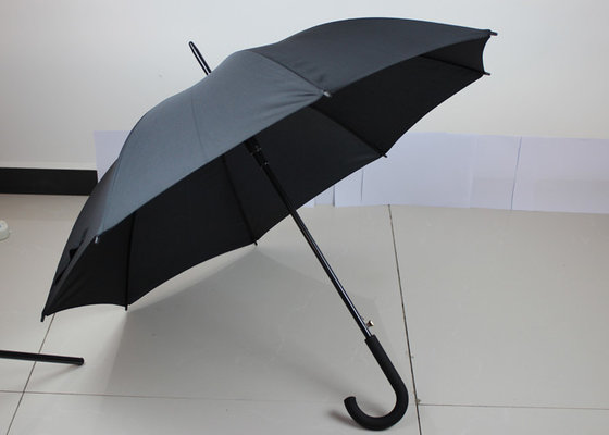 Parapluie se pliant droit ouvert de golf d'automobile, parapluie noir du golf des hommes protégeant du vent